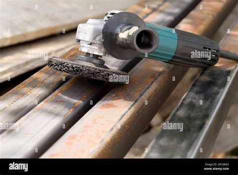 Not New Electric Angle Grinder Tool Lies On A Rust Metal Square Tube Rust Removal With Wire
