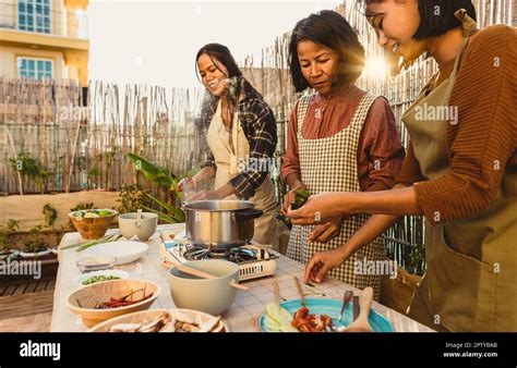 Southeast Asian Mother With Her Daughters Having Fun Preparing Food