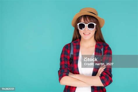 아름 다운 초상화 젊은 아시아 여자 선글라스와 모자 미소 표현을 자신감을 착용 여름 휴일 고립 된 파란색 배경 배낭 여행 개념 모델 소녀 패션을 즐길 수 있습니다 가방에