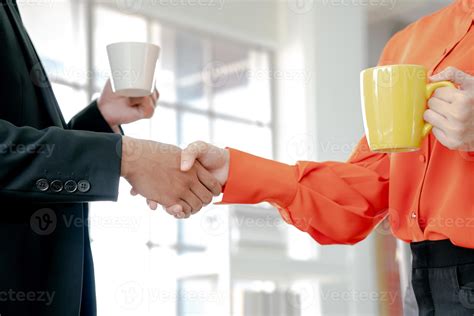Business People Shaking Hands While Having A Cup Of Coffee 10048263