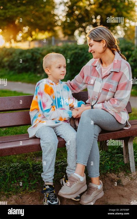 Mutter Und Sohn Sitzen In Den Sonnenstrahlen Des Sonnenuntergangs Auf