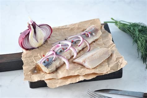 종이와 도마에 대서양 청어의 필레 물고기에는 붉은 양파와 후추의 반 고리가 있습니다 다음 반으로 양파 딜 건강한 생활방식에 대한 스톡 사진 및 기타 이미지 Istock