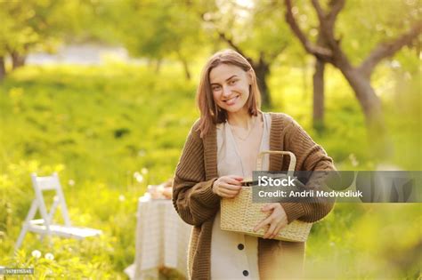 젊은 웃는 여자는 밝은 자연에서 음식이 담긴 고리 버들 바구니를 들고 있다 아름다운 소녀가 여름에 공원에서 피크닉을 하고 있다 건강에 좋은 음식 사람 라이프 스타일 휴식 및