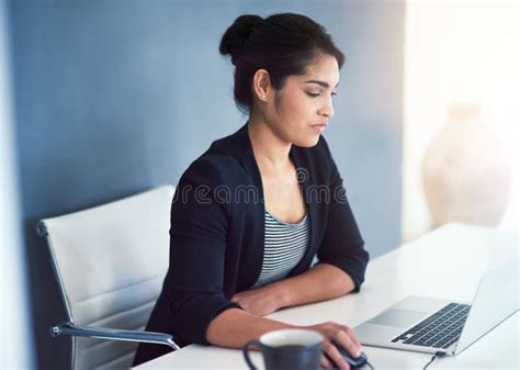Social Networking Businesswoman With Laptop And At Her Desk In A Modern Workplace Office With A