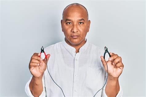 Middle Age Latin Man Holding Battery Charge Clippers Relaxed With
