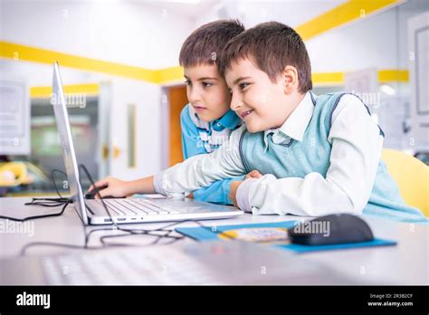 Smiling Babe Sharing Laptop With Friend At Computer Class In Babe Stock Photo Alamy