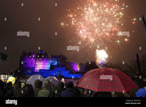 Revellers Watch Fireworks At Edinburgh Castle During The Hogmanay New Year Celebrations In