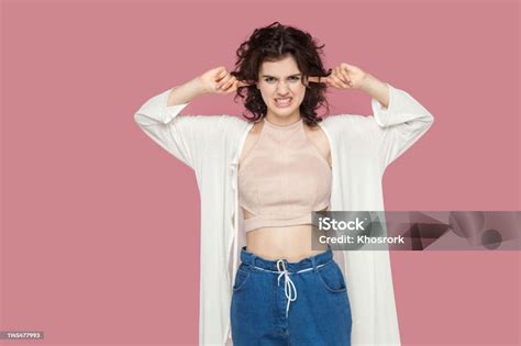 나는 이것을 듣고 싶지 않아요 불만족 한 갈색 머리의 초상화 캐주얼 스타일의 곱슬 헤어스타일을 가진 젊은 여자는 서 있고 그녀의