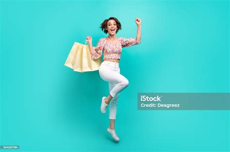 미친 듯이 기뻐하는 아가씨의 전신 초상화는 주먹을 들고 청록색 배경에 격리된 쇼핑몰 가방을 들고 있다 소매 소비자주의에 대한 스톡 사진 및 기타 이미지 Istock