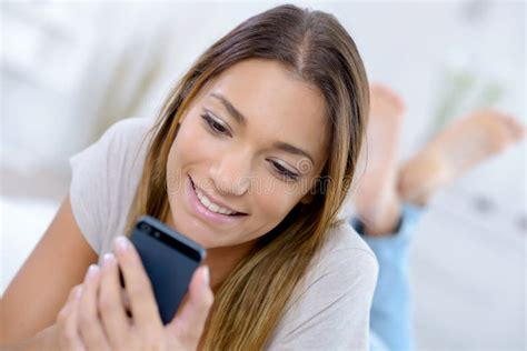 Woman Reading Text Message While Lying On Bed Stock Image Image Of