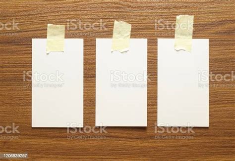 나무 표면에 노란색 테이프로 붙어있는 3 개의 빈 명함 디자인 프리젠 테이션 쇼케이스 등을위한 템플릿으로 35 X 2 인치 크기