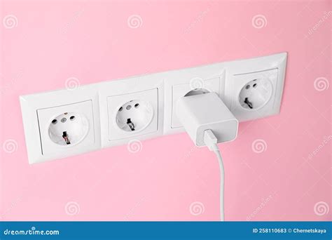 Charger Adapter Plugged Into Power Sockets On Pink Wall Electrical Supply Stock Image Image