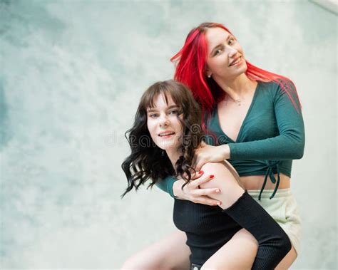 Two Friends Are Fooling Around Young Caucasian Woman On The Back Of