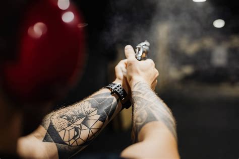 Download Hd Tattoo Person Holding Gun Wallpaper Wallpapers Com