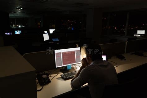 Caucasian Male Programmer Sitting At Desk Using Computer With Coding