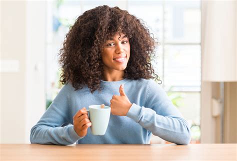 아프리카계 미국인 여자에 커피 한 잔을 들고 확인 서명 하 고 큰 웃음과 함께 행복 한 가정 손가락 우수한 로그인으로 엄지 개념에 대한 스톡 사진 및 기타 이미지 Istock