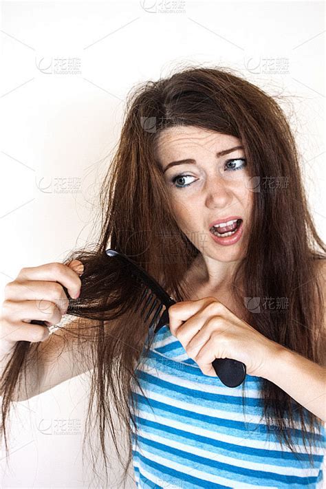 女孩使劲梳理她那乱糟糟的受损头发