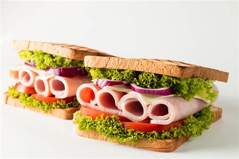 클럽 샌드위치의 클로즈업 사진 고기 프로슈토 살라미 샐러드 야채 양상추 토마토 양파 겨자를 나무 배경에 신선한 슬라이스 호밀 빵에 샌드위치 올리브 배경입니다 0명에 대한