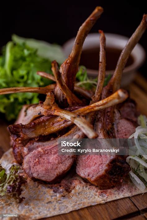 뼈에 구운 양고기 조각 로메인 상추 로즈마리 양파 링 피타 빵을 나무 판에 곁들입니다 수직 방향 0명에 대한 스톡 사진 및 기타