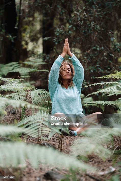 한 자연의 건강한 여성은 숲의 푸른 숲에서 요가 운동을 명상하고 자연 속에서 야외 레저 활동을 즐긴다 웰빙과 마음챙김 운동은 밖에 있는 사람들입니다 사람들은 명상한다 개념에