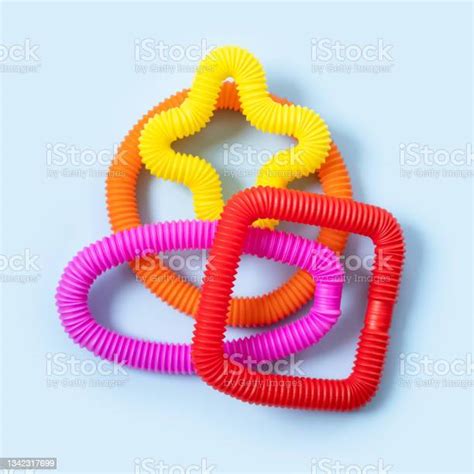 블루 배경에 아이들을위한 다채로운 안티 스트레스 안절부절 푸시 팝 튜브 감각 장난감 상단 보기 플랫 레이 인기있는 플라스틱 유연한 밝은 골판지 파이프와 창조적 인 게임의