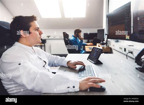 Side View Waist Up Of Two It Programmers Coding In A Bright Office With Lost Of Natural Light