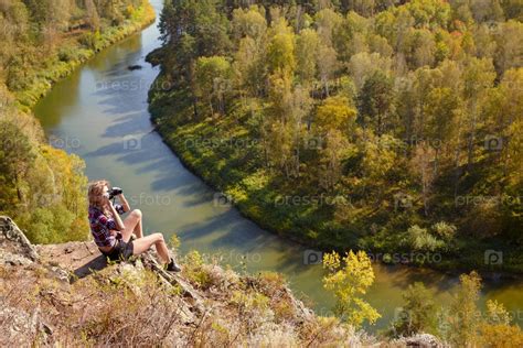 Фотография на тему Молодая блондинка туристка на скале смотрит в