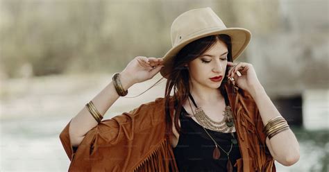 바람이 부는 머리 프린지 판초와 액세서리를 쓴 모자를 쓰고 포즈를 취하는 세련된 힙스터 여성 집시 룩의 보헤미안 여행자 소녀 여름 여행 대기 순간 텍스트 공간