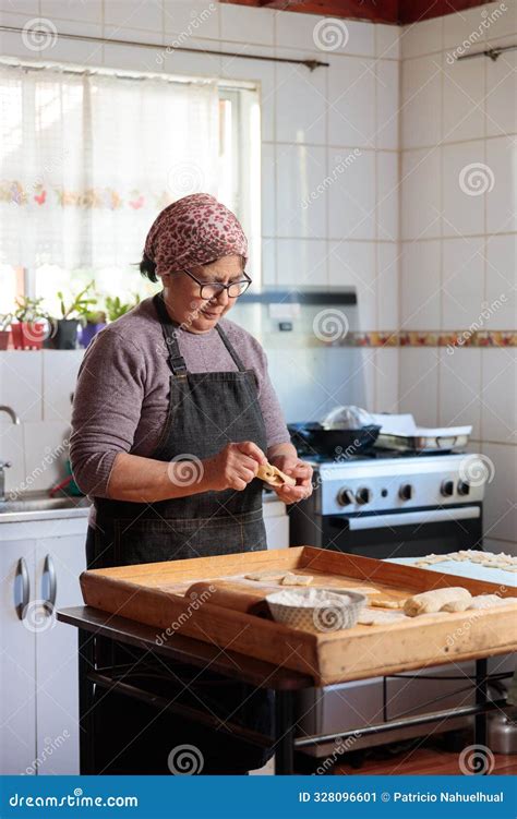 Traditional Latin Senior Woman Cooking And Preparing Homemade Meal In