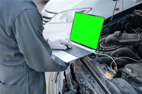 Premium Photo | Skilled mechanic using a laptop computer to check collect information during ...