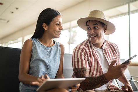 공항에서 아내에게 휴대 전화로 무언가를 보여주는 중년 성인 남성 커플에 대한 스톡 사진 및 기타 이미지 커플 라틴 아메리카 히스패닉 민족 말하기 Istock