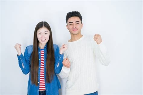 흰색 고립 된 배경을 통해 아름다운 젊은 아시아 부부는 팔을 들고 눈을 뜨고 성공을 축하하고 놀랐습니다 우승자 컨셉 2명에 대한 스톡 사진 및 기타 이미지 Istock