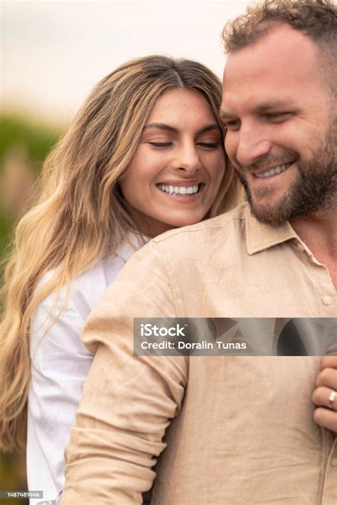 부부는 따뜻하고 사랑스러운 포옹으로 포옹하고 행복과 기쁨으로 빛나는 얼굴로 서 있습니다 그들의 사랑은 순수한 행복의 순간에 길을 잃은 서로를 붙잡는 방식에서 분명합니다 25