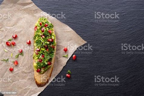 배경의 오른쪽에 양피지 종이에 아보카도 석류와 딜 씨앗으로 만든 하나의 카나페가 있다 클로즈업 건강한 생활방식에 대한 스톡 사진 및 기타 이미지 Istock