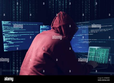 Cyber Attack Anonymous Hacker Working With Laptop And Monitors On Dark