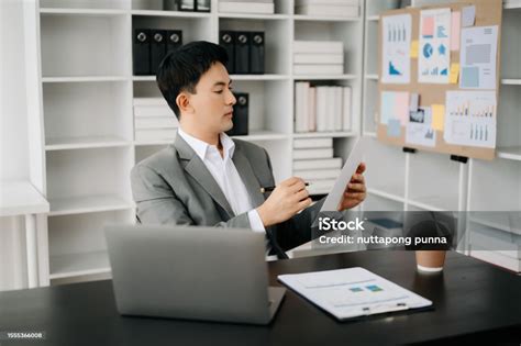 젊은 사업가가 사무실에서 노트북과 태블릿을 들고 종이에 메모를 하고 있다 35 39세에 대한 스톡 사진 및 기타 이미지 35 39세 가상현실 남성 Istock