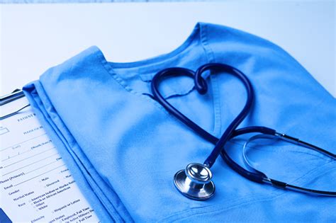 청진 기 의료 환자 의료 기록 목록 및 블루 의사 유니폼 근접 촬영에 심장 모양에 트위스트 의료 도움 또는 보험 개념입니다 심장 치료 건강 보호 및 예방 건강관리와 의술에