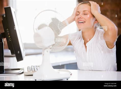 Businesswoman In Office With Computer And Fan Cooling Off Stock Photo Alamy