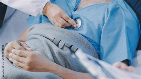 A Doctor Examining A Middle Aged Male Patient In A Coma In A Hospital