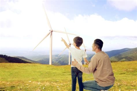 Father With Son Looking At Wind Energy Turbines Premium Photo