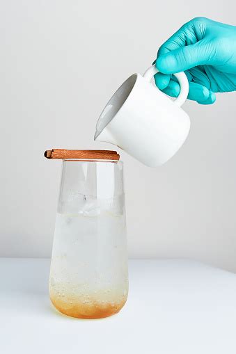 위생과 안전을 위해 장갑을 끼고 음료를 만드는 바리스타 유리잔을 들고 아이스 스파클링 소다 잔에 커피를 붓는다 카페의 하얀