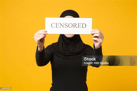 히 잡 검은 옷에 젊은 아라비아 무슬림 여자 노란 벽 배경 스튜디오 초상화에 고립 된 검열 제목으로 손 기호를 잡고 사람들 종교적 라이프 스타일 개념입니다 복사 공간을 모의