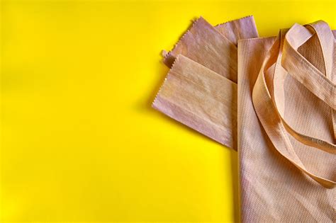 재활용 폐기물로 만든 토트 백과 밝은 노란색 배경의 재사용 가능한 종이 패키지 제로 폐기물 라이프 스타일 생태 안전 재활용 폐기물 환경 보호 지구의 날의 개념 0에 대한