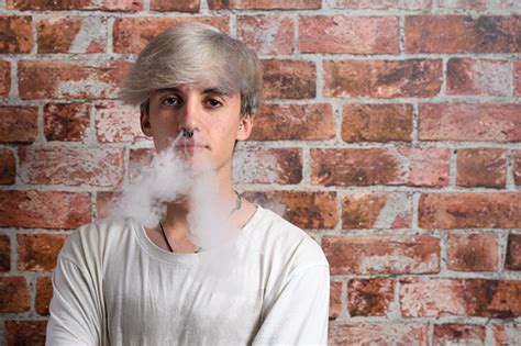 벽돌 벽 근처에 야외 전자 담배를 연기 합니다 젊은 남자 흡연 큰 구름의 증기 건강관리와 의술에 대한 스톡 사진 및 기타 이미지 건강관리와 의술 검은색 구름 풍경