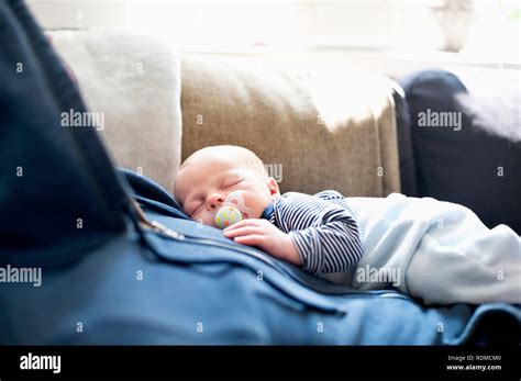 Father Sleeping On Sofa With Baby Son Stock Photo Alamy