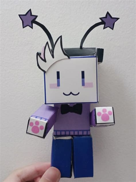 A Person Holding Up A Paper Toy With Stars On It