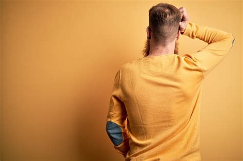 잘 생긴 아일랜드 빨강 머리 남자 와 수염 착용 안경 위에 노란색 고립 된 배경 뒤로 생각에 의심에 대 한 생각 에 손으로 머리에 남자에 대한 스톡 사진 및 기타 이미지