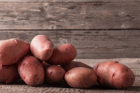 Premium Photo Red Potatoes On Wooden Background