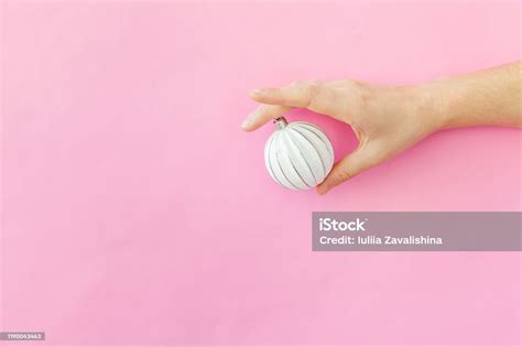 분홍색 파스텔 컬러의 트렌디 한 배경에 고립 된 크리스마스 장식 공을 들고 있는 최소한의 디자인 여성 12월에 대한 스톡 사진 및 기타 이미지 Istock