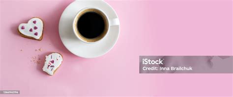 에스프레소와 진저브레드를 곁들인 화이트 컵과 접시는 흰색 아이싱으로 덮여 핑크 색배경에 뿌려져 있습니다 발렌타인 데이를 축하하는 개념 가로 방향입니다 복사 공간을 복사합니다